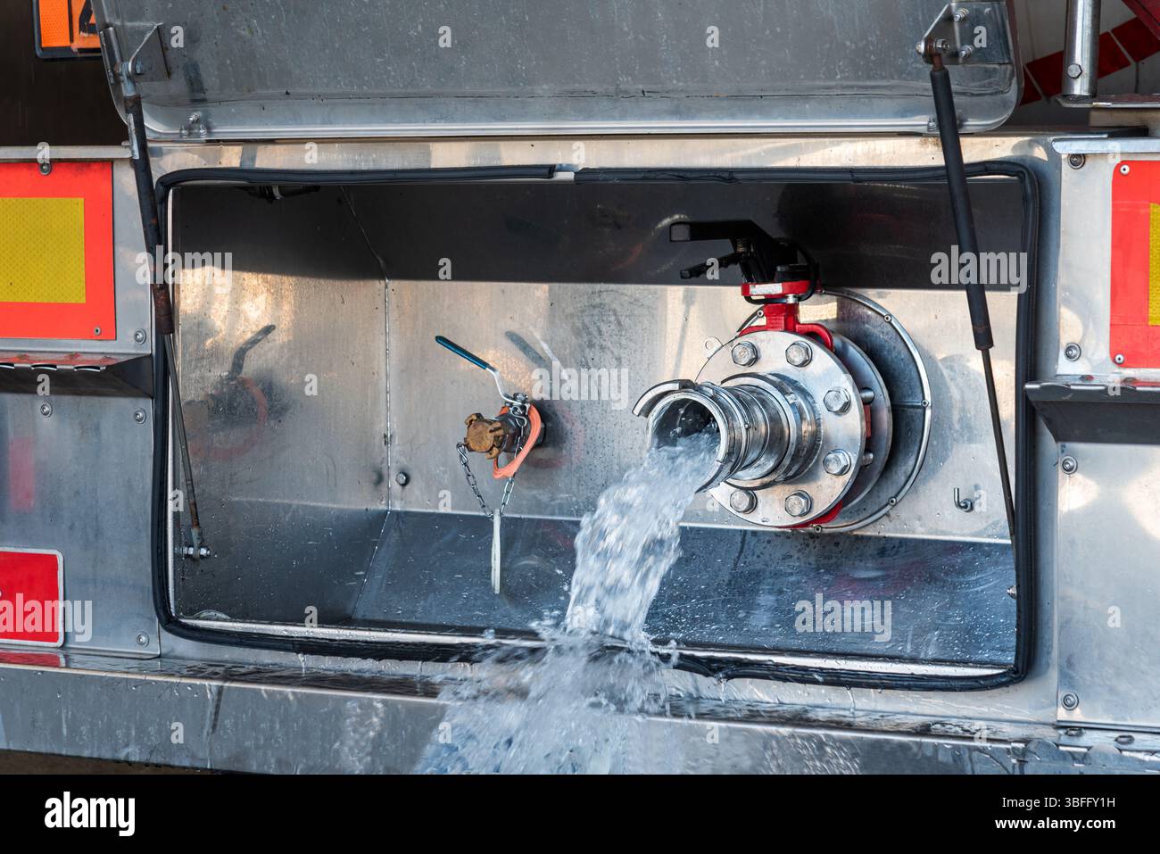 Open discharge mouth of a tanker truck spilling the water used for its ...