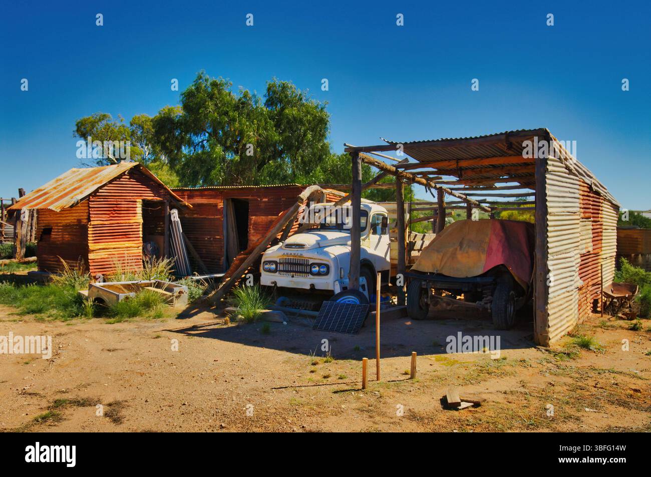Abandoned farm buildings made of rusted corrugated metal and the wreck ...
