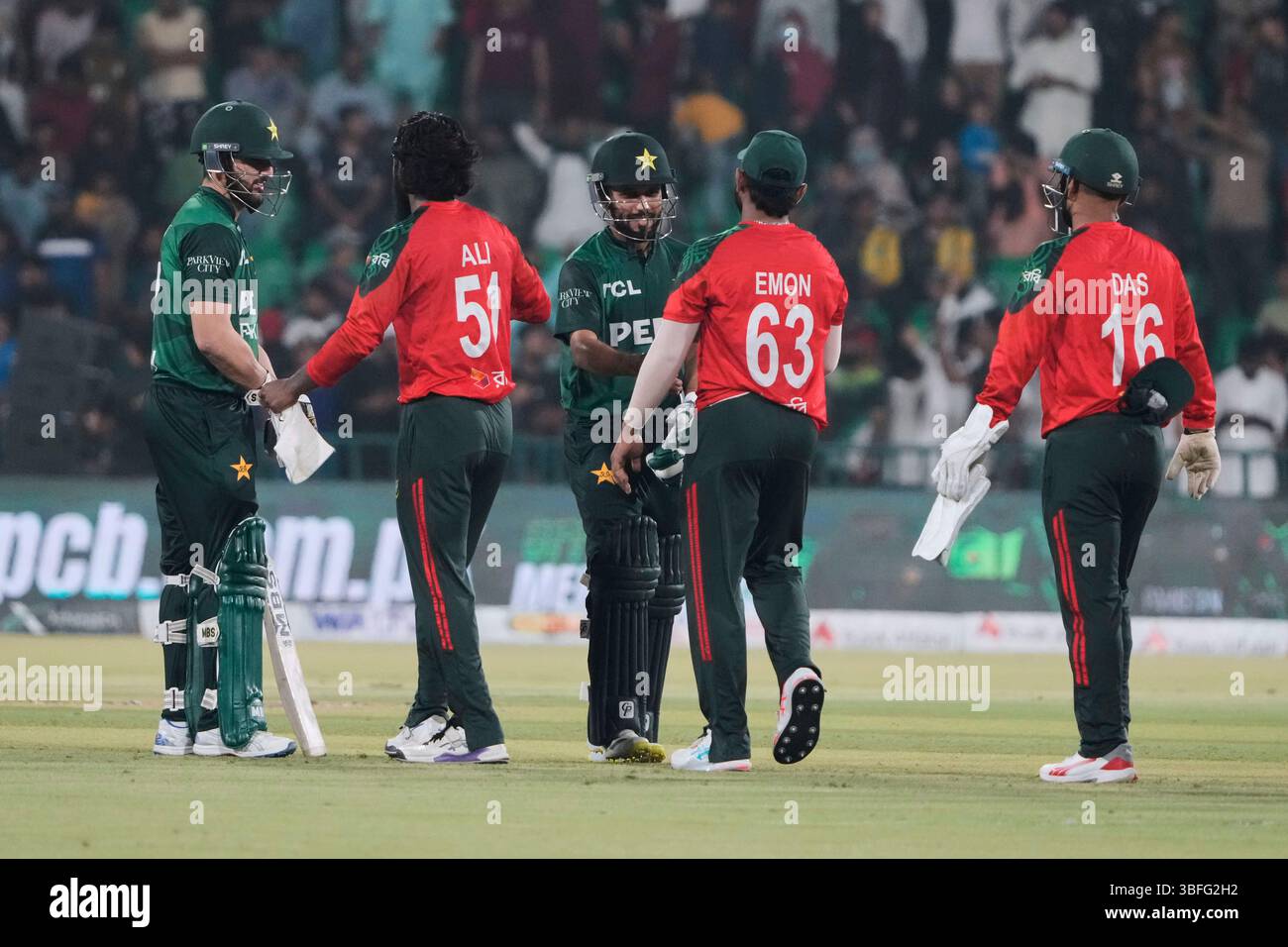 Pakistan's Mohammad Haris, center, and Salman Ali Agha, left, shake hand with Bangladesh players ...