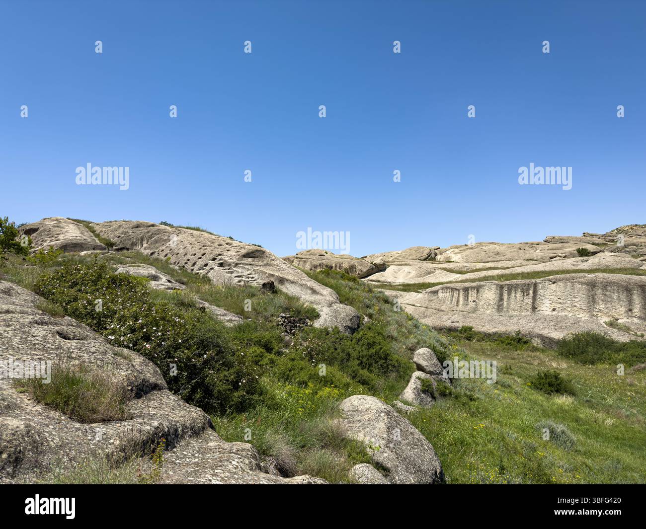 Rocky hills and grassland with textured stone surfaces and erosion ...