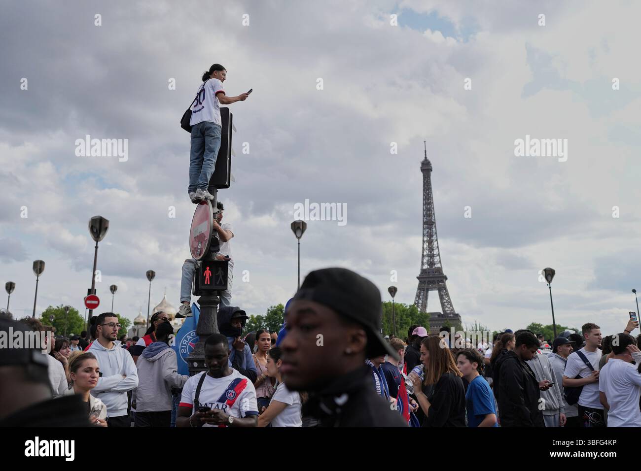 PSG supporters react in front of the Eiffel Tower after a parade on the ...