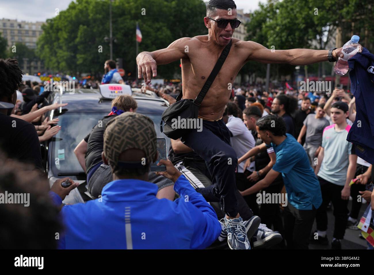 PSG supporters react after a parade on the Champs-Elysees avenue ...