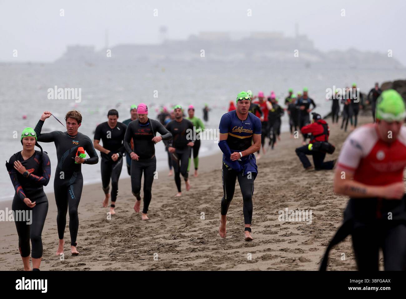 Athletes run on the beach during the "Escape From Alcatraz" triathlon ...