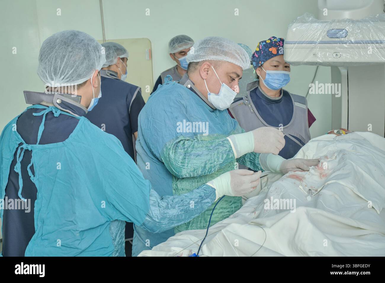 Doctors perform cardiac catheterization, inserting a thin catheter ...