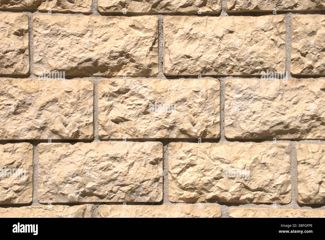 Close-up full-frame beige stone wall with rough, natural texture and ...