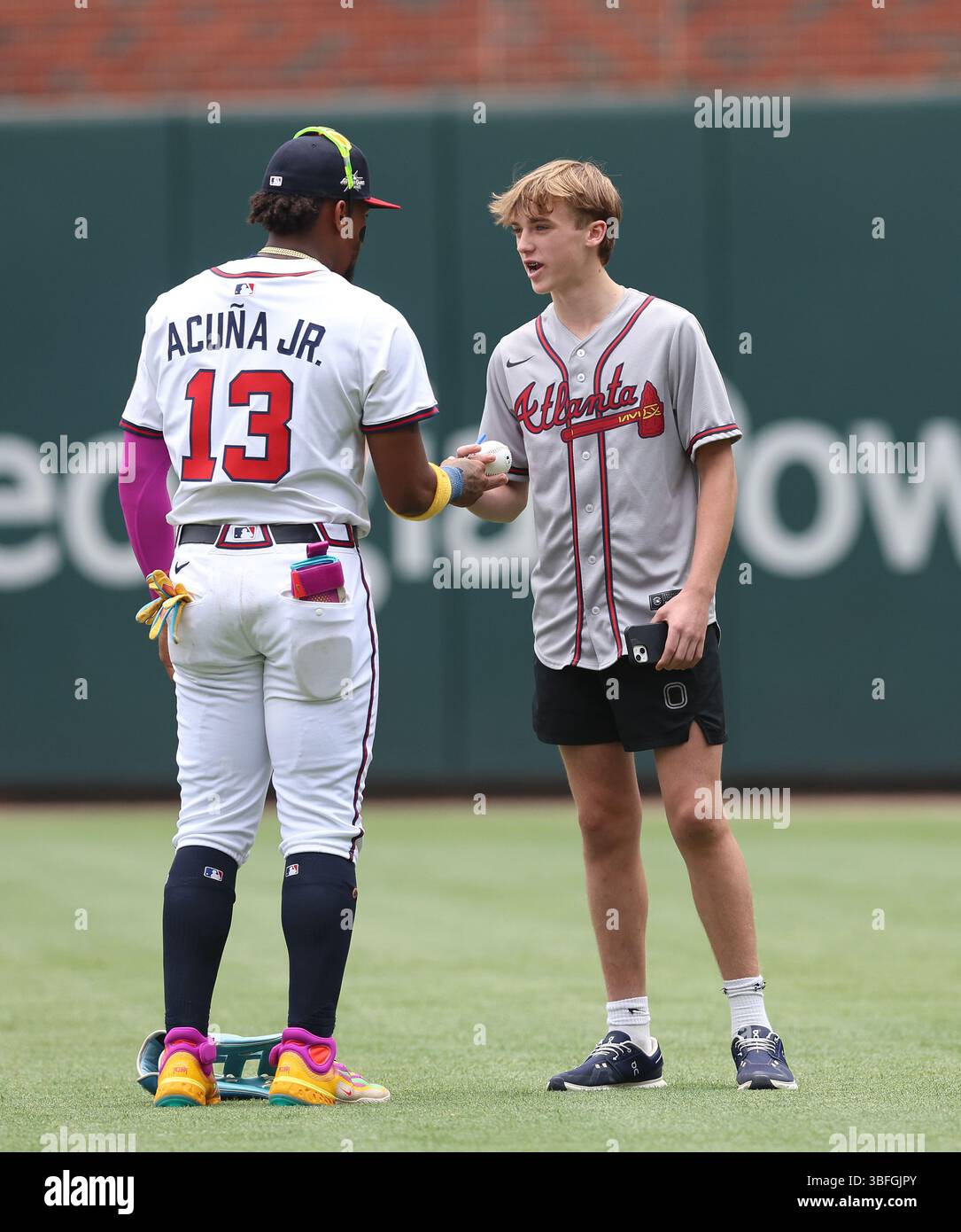 Right fielder Ronald Acuna, Jr. #13 of the Atlanta Braves signs a ball ...