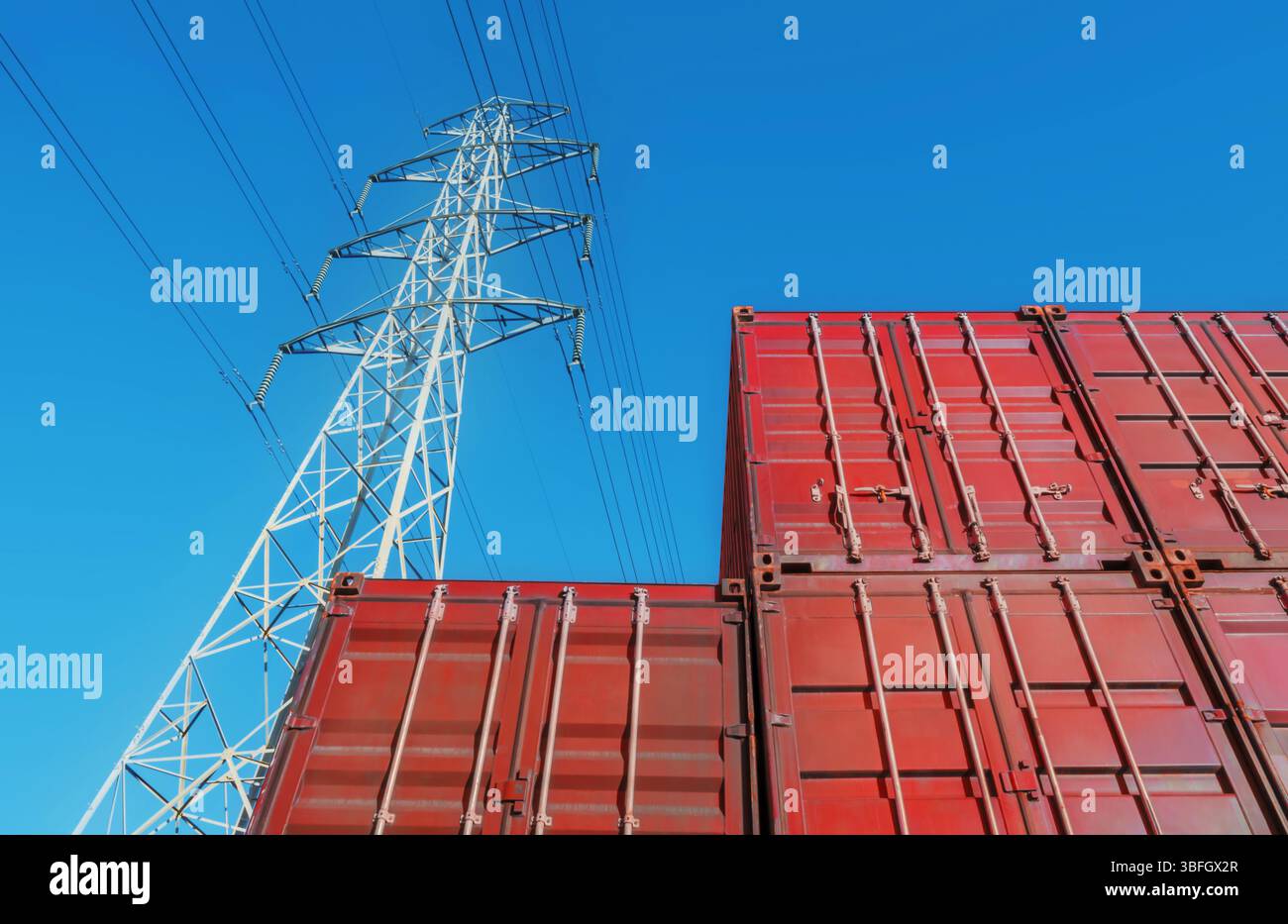 Red cargo containers stacked high with electricity power lines in ...