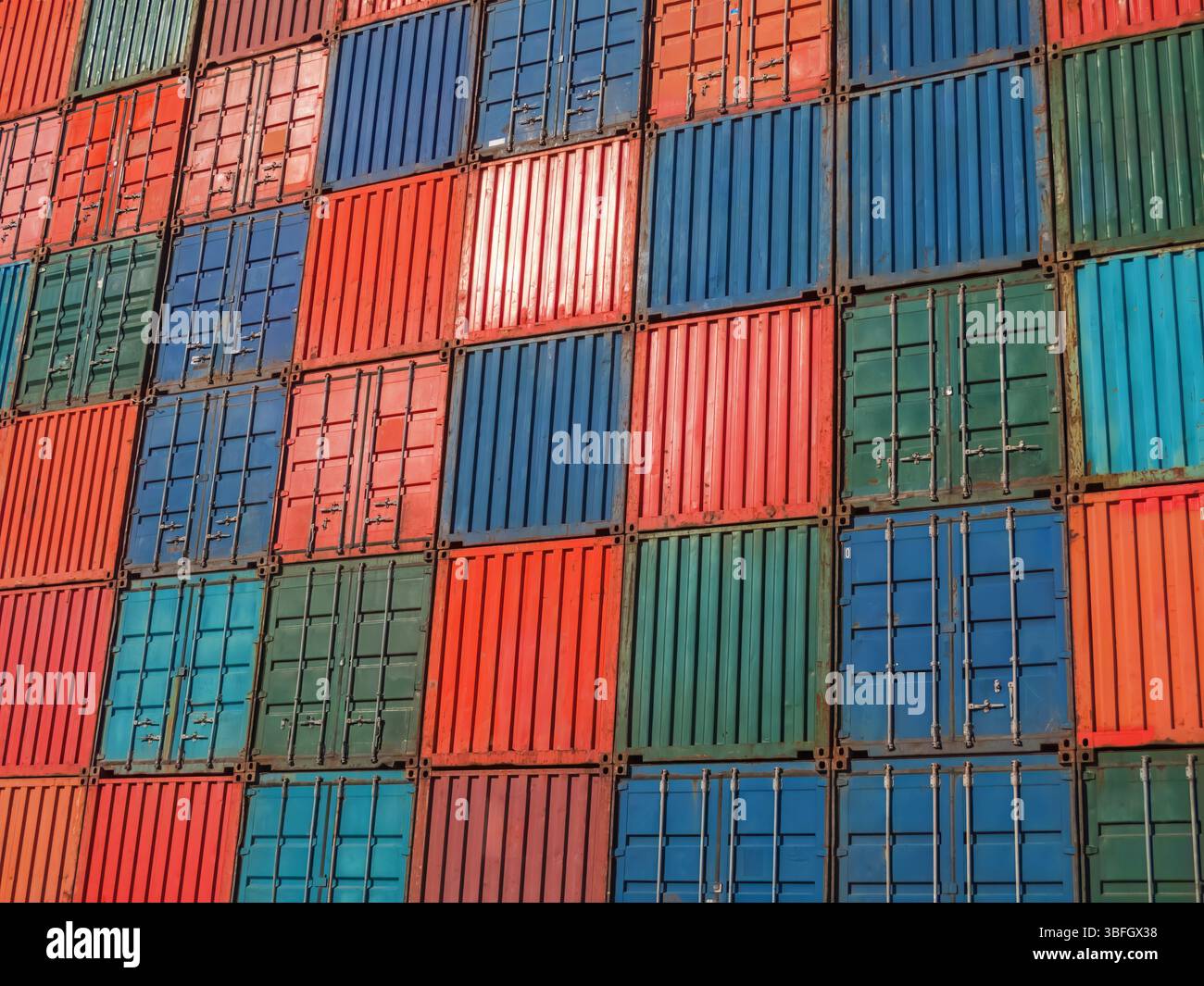 Grid pattern of a tall stack of colorful cargo shipping containers ...