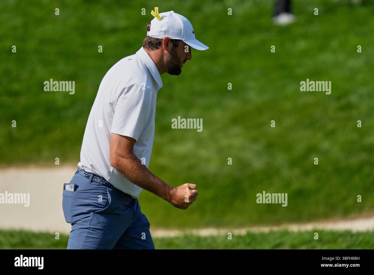 Scottie Scheffler pumps his fist as he sinks a putt on the 14th green ...