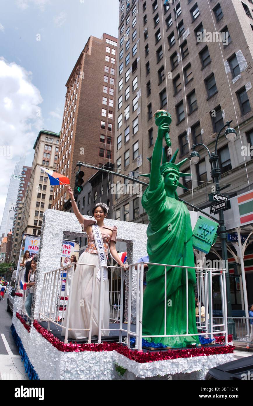 A parade float features Miss New York USA, a green Statue of Liberty ...