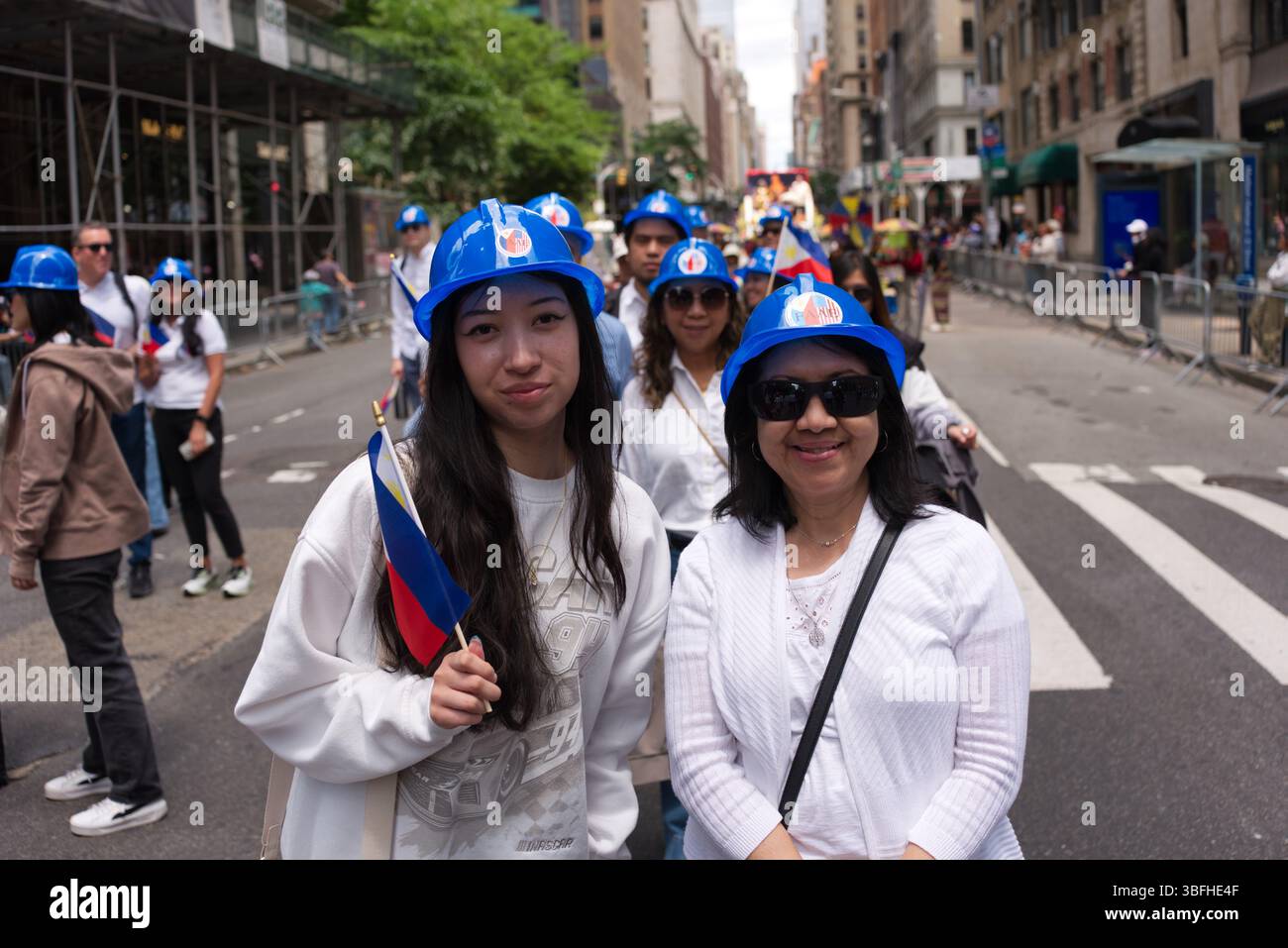 A group of people, primarily women and girls, wearing blue hard hats ...