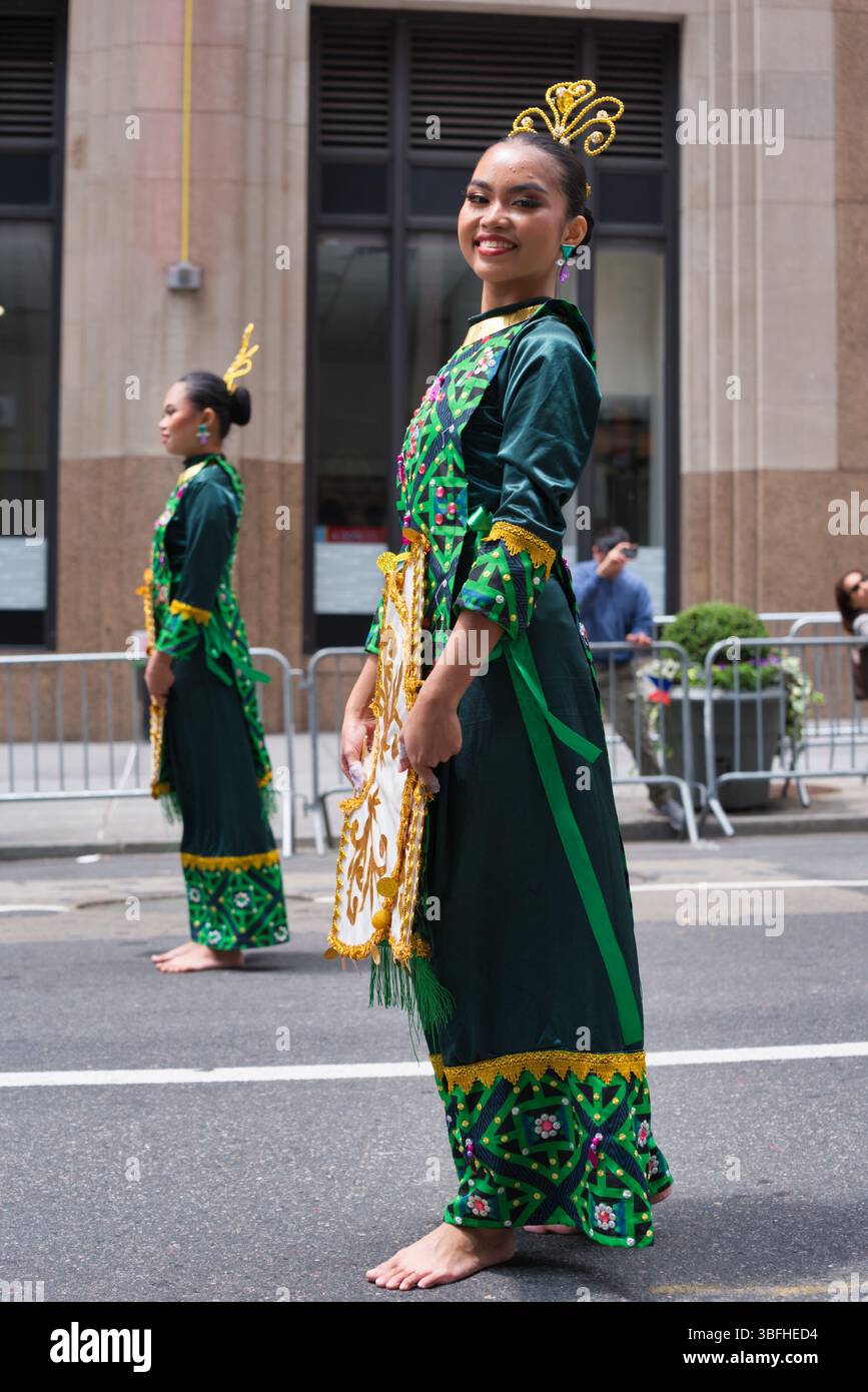 Two women in traditional green and gold Southeast Asian attire, one ...