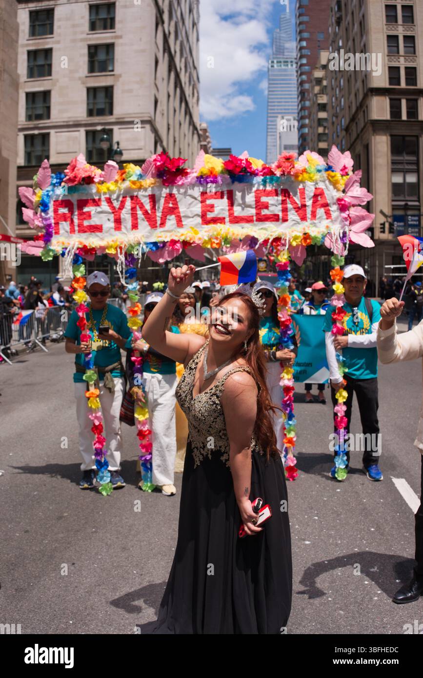 A woman in a black gown stands under a floral archway that reads "Reina ...