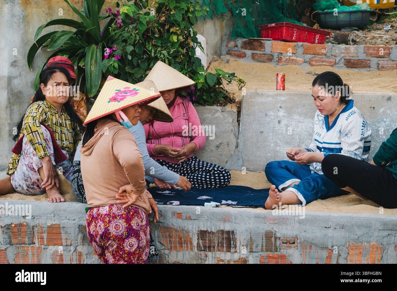 Asian Vietnamese elderly women playing cards on the street in village in Vietnam in Asia. Xuan ...