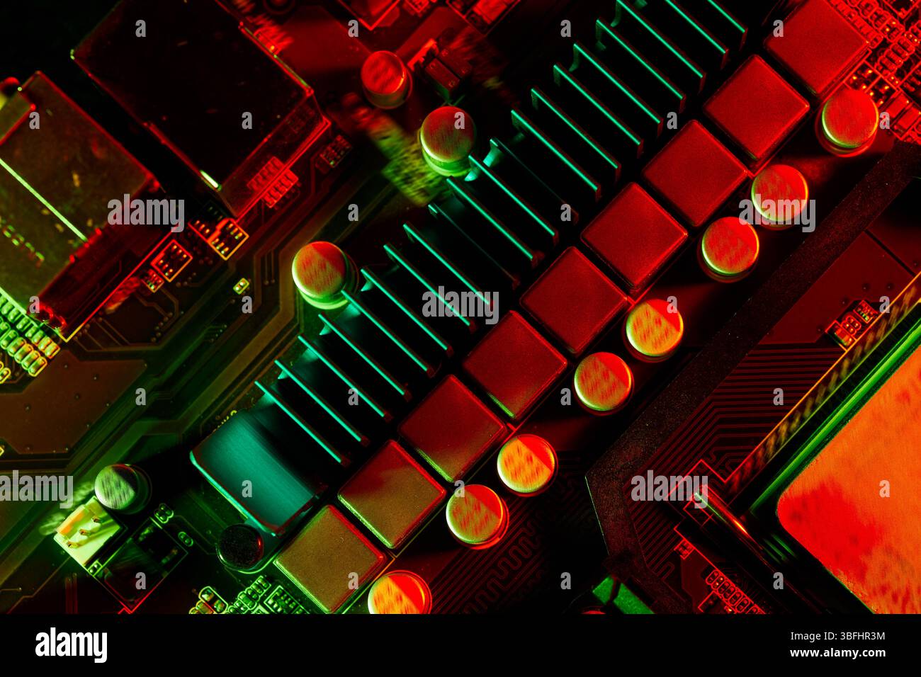 A detailed motherboard close-up with green and red lights accentuating ...