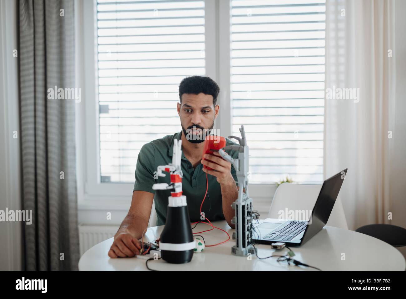 Engineer testing robotic arm circuitry using a multimeter Stock Photo ...