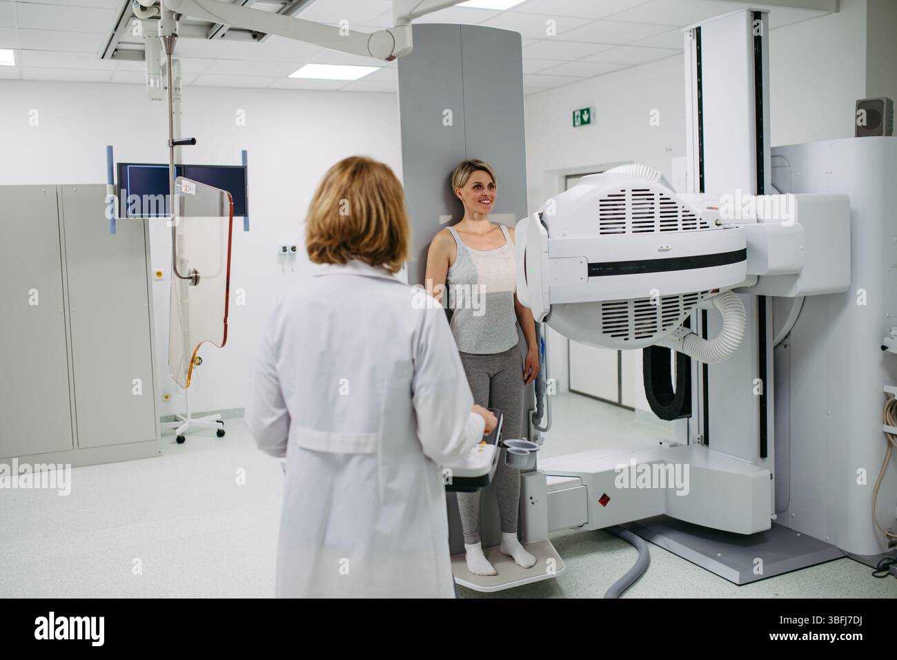 Doctor operating dynamic X-ray scan using tilting fluoroscopy unit ...
