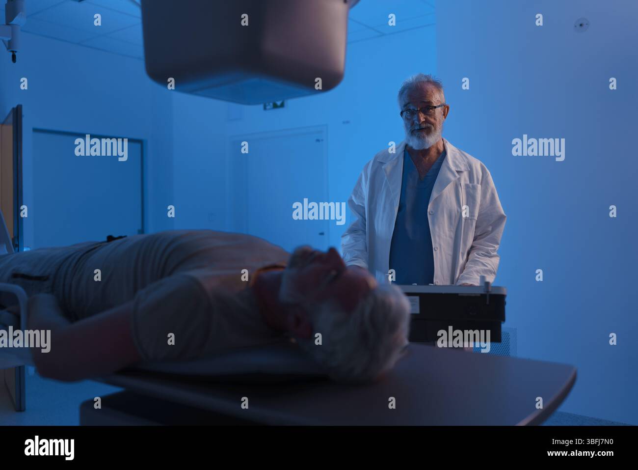 Male patient undergoing X-ray examination using tilting radiographic ...