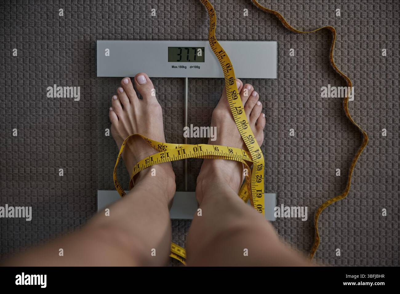 Unrecognizable woman standing on floor scales displaying low weight ...
