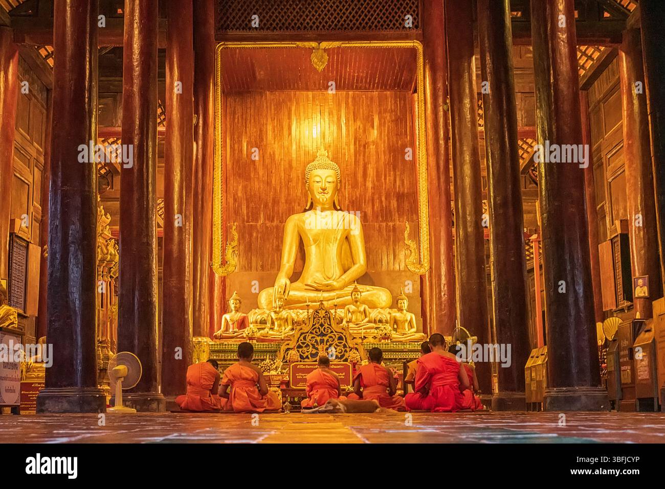 rear view of monks and novices chanting evening prayers in old chapel ...
