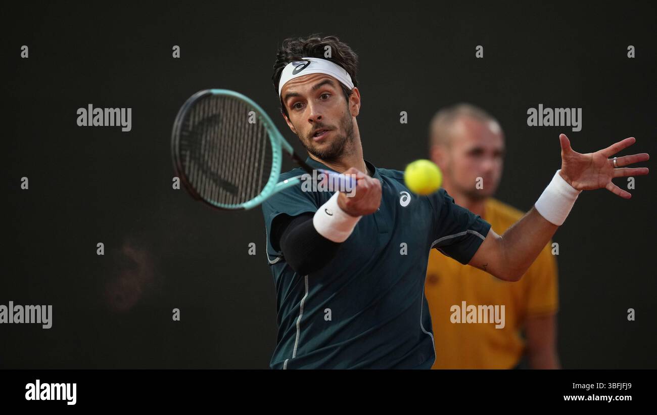 Italy's Lorenzo Musetti returns the ball to Denmark's Holger Rune ...