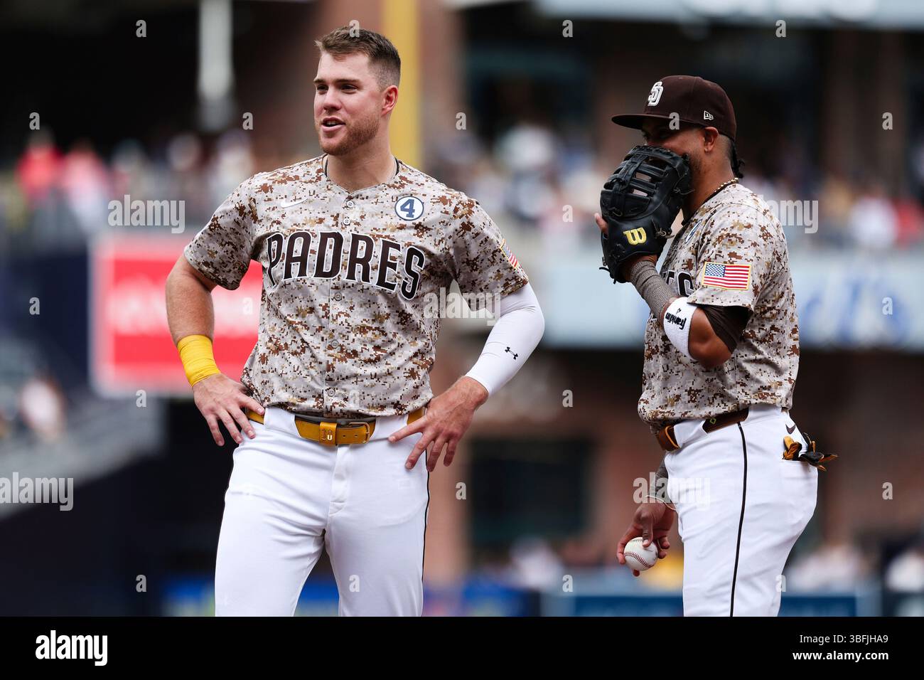 San Diego Padres' Gavin Sheets, left, talks with Luis Arraez in between ...