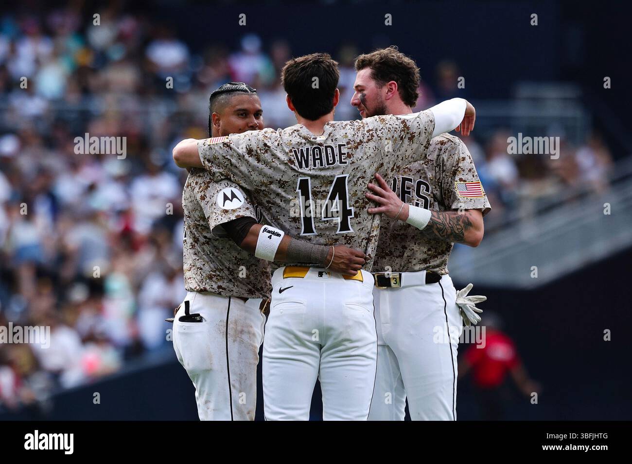 San Diego Padres' Tyler Wade (14) embraces Luis Arraez, left, and ...