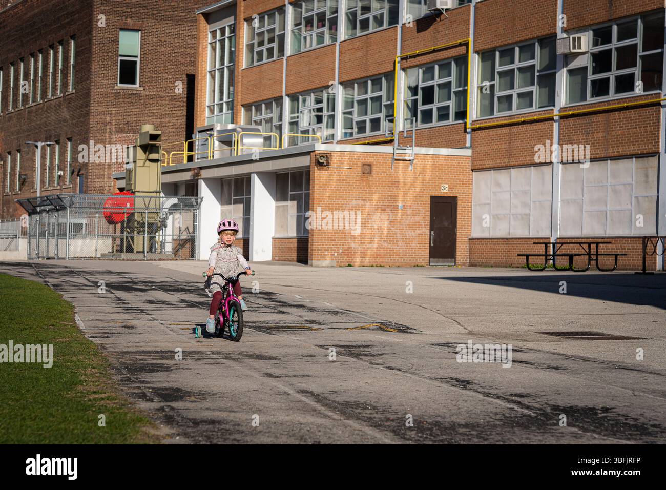 A child of preschool age riding a bike on a school track Stock Photo ...