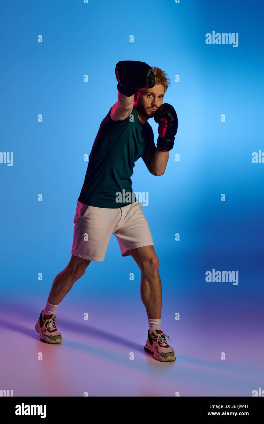 A young man practices his boxing skills in a colorful studio ...