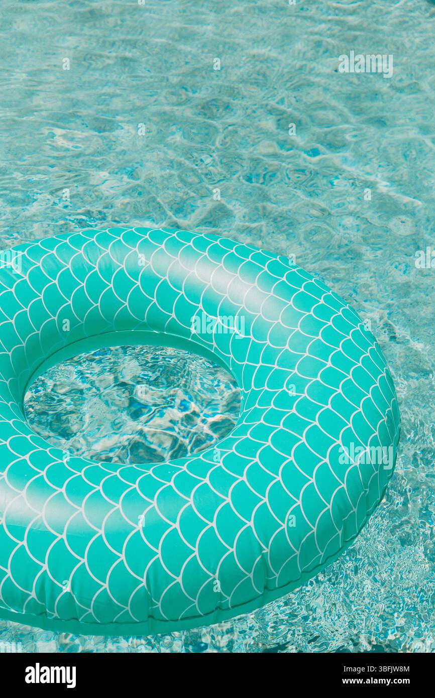 Teal mermaid-print float drifting in clear pool water Stock Photo - Alamy
