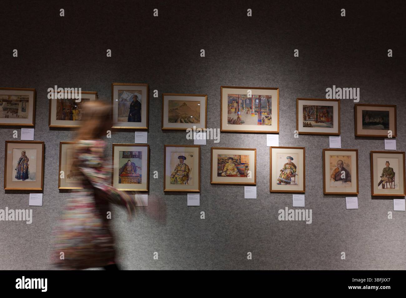 A Bonhams employee walks past a collection of paintings by Kanwal ...
