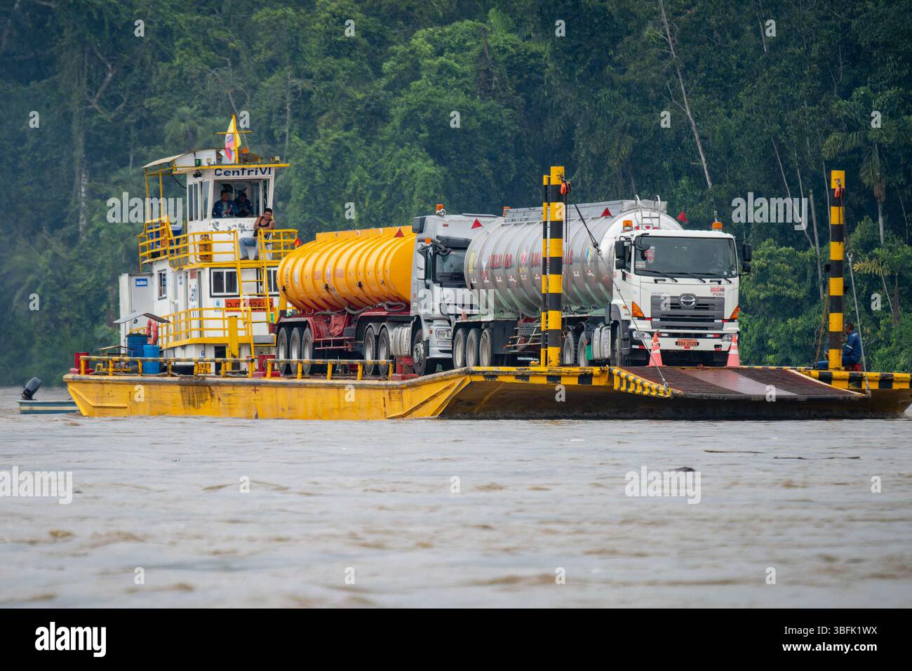 An oil industry barge carrying oil tanker trucks on the Napo River in ...