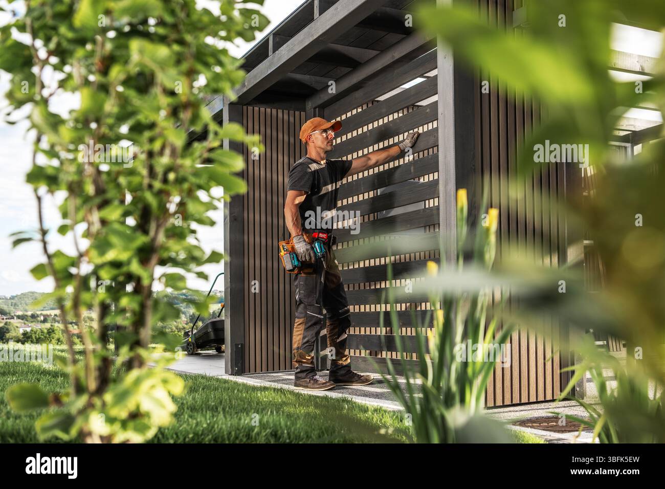 A construction worker focuses on assembling a wooden frame in a ...