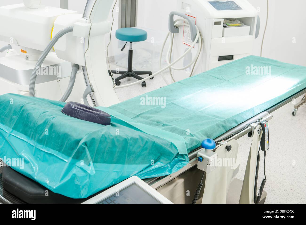 Surgical table is covered in green preparation materials as medical ...