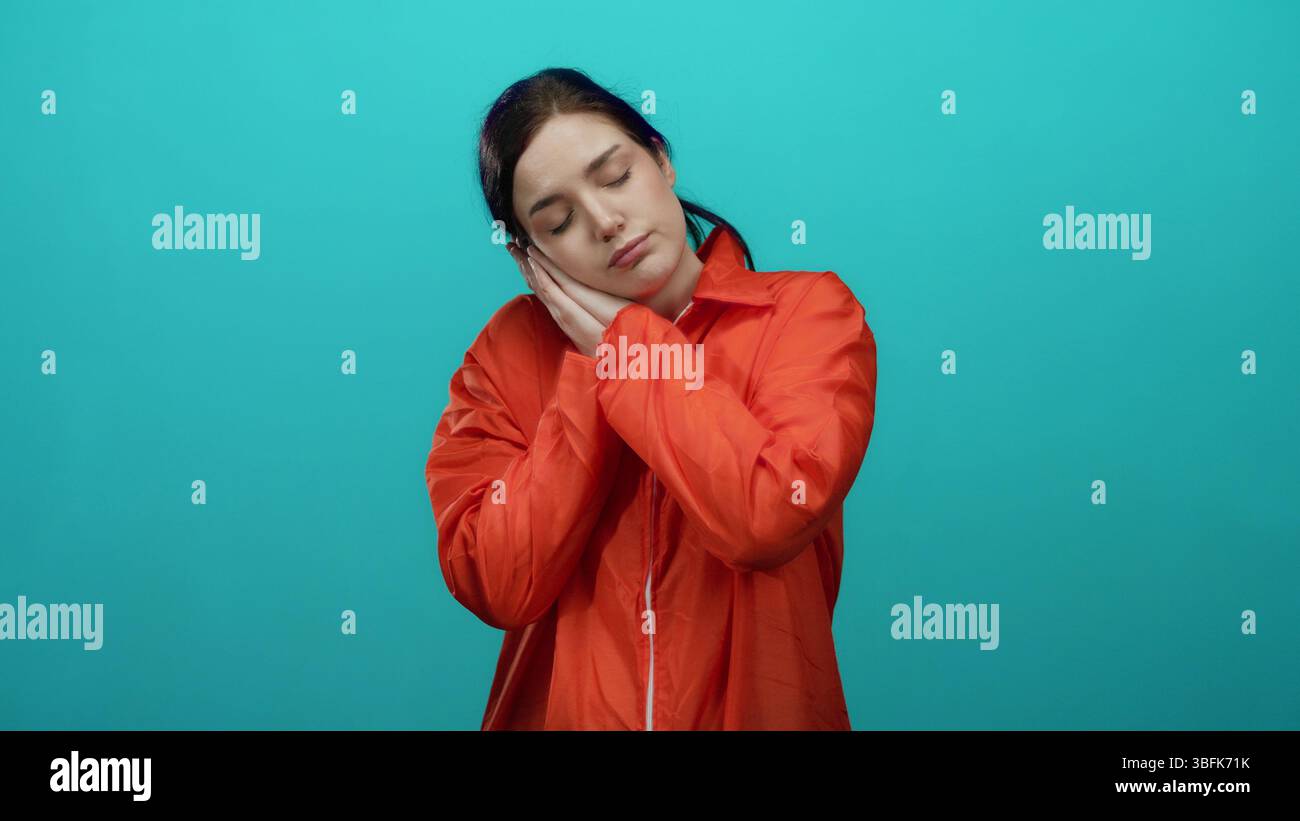 Woman wearing orange prison jumpsuit appearing sleepy in front of a ...