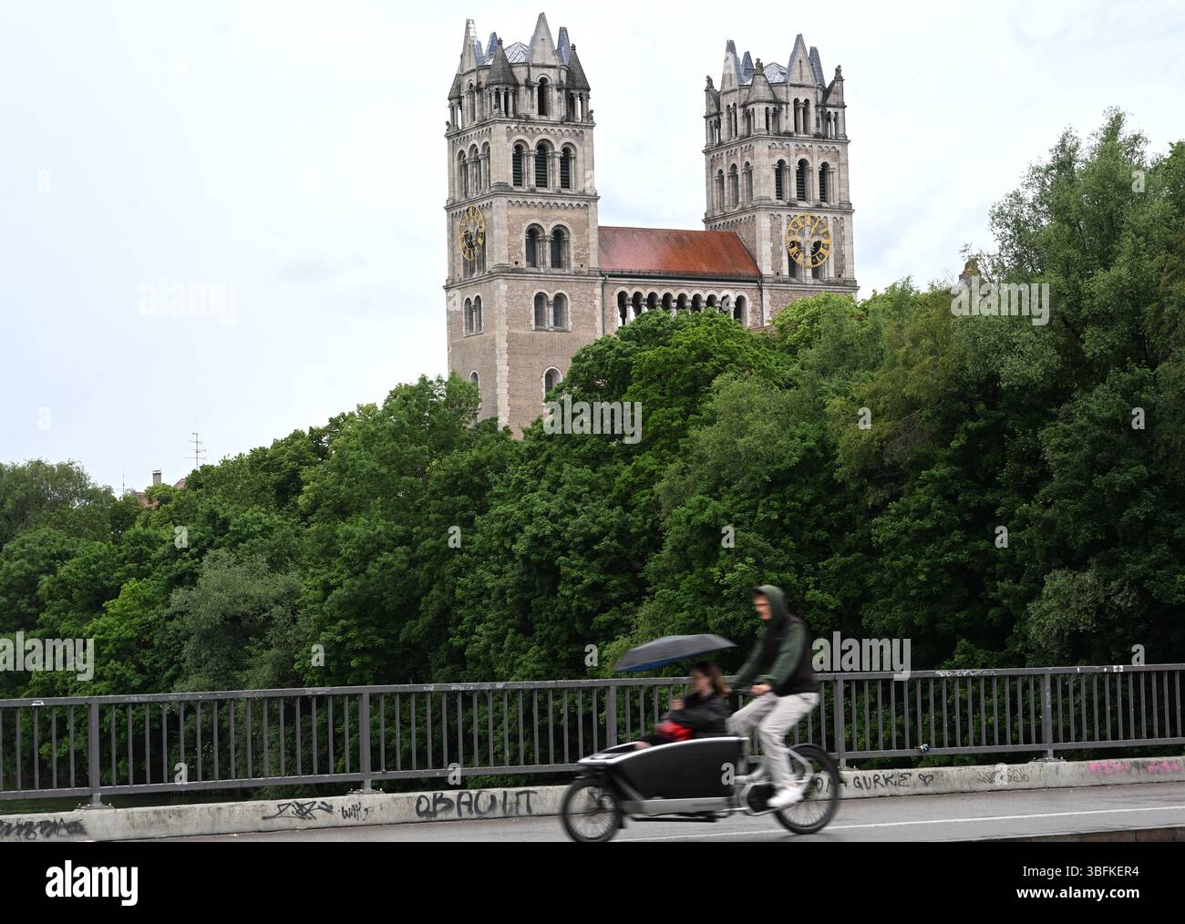 Munich, Germany. 02nd June, 2025. A man rides a cargo bike in the rain ...