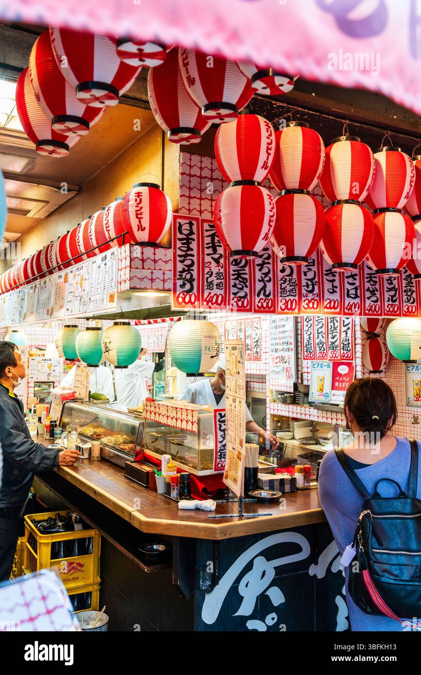 Two customers at the food bar of a typical Japanese diner. The Yamatoya ...