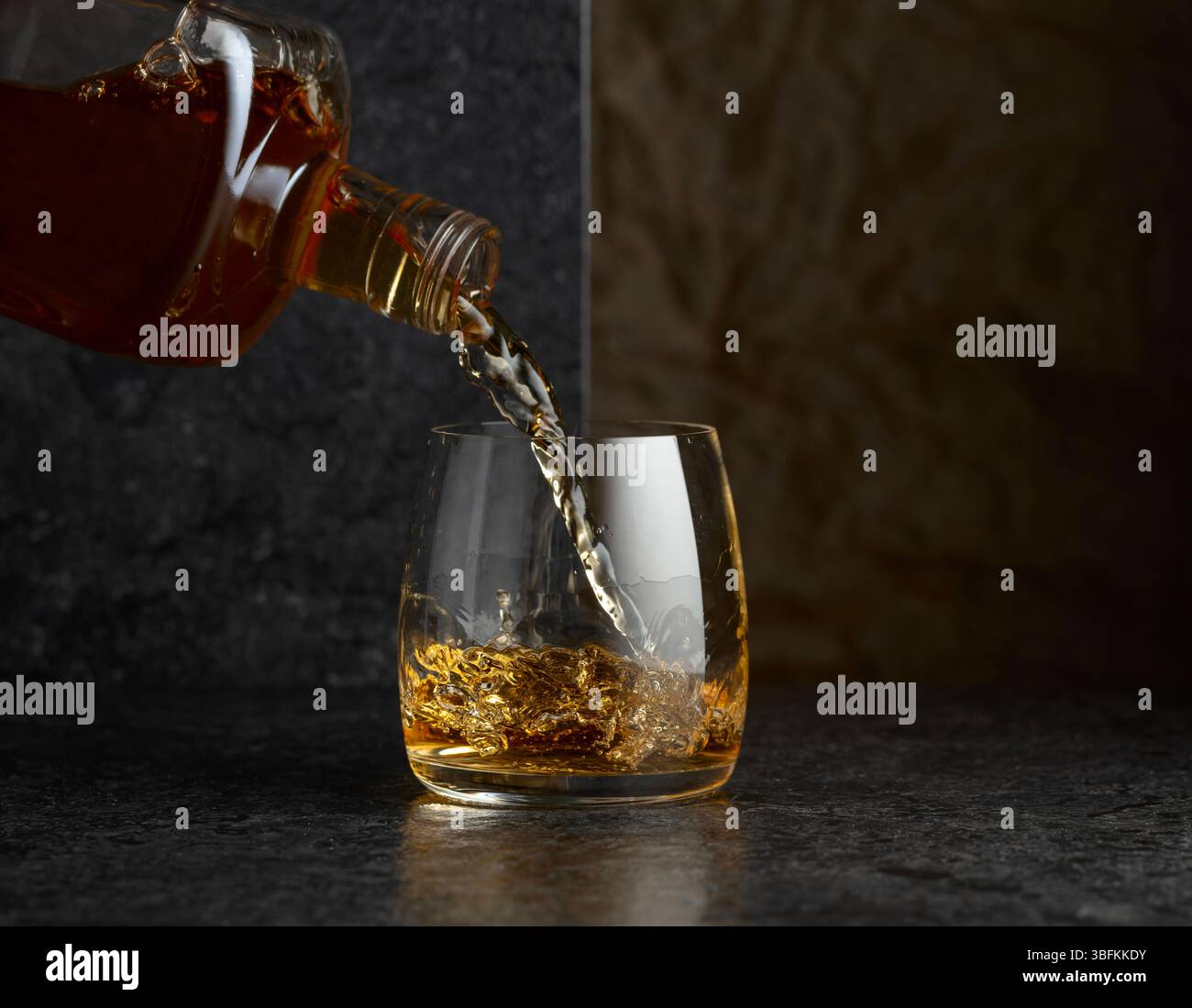 Pouring whiskey from a bottle into a glass. Copy space Stock Photo - Alamy