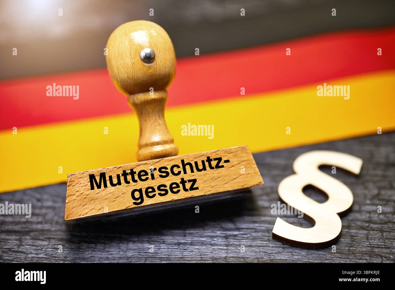 FOTOMONTAGE, Stempel mit Aufschrift Mutterschutzgesetz und Paragrafenzeichen vor deutscher Fahne ...