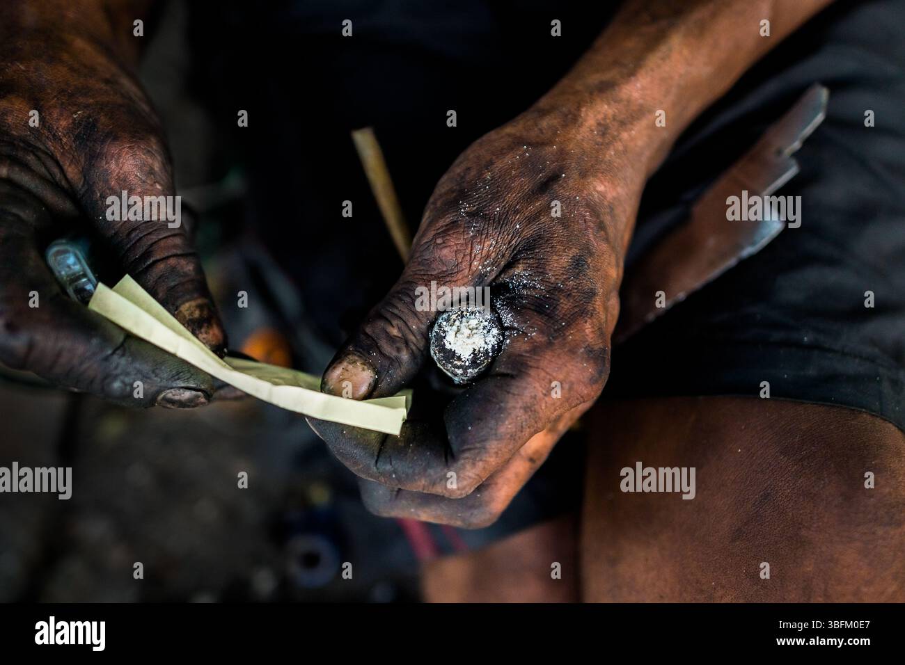 A Colombian drug user holds a homemade pipe loaded with basuco – an ...