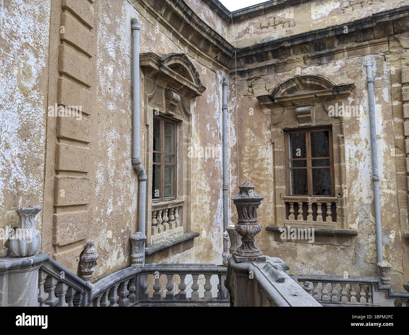 Weathered walls and ornate architectural details with classical windows ...