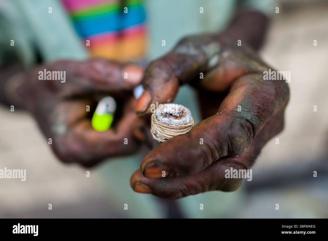 A Colombian drug user holds a homemade pipe loaded with basuco – an ...