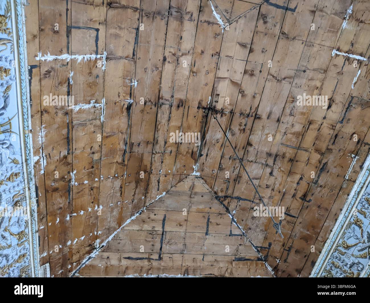 A vintage wooden ceiling with visible planks and construction details ...