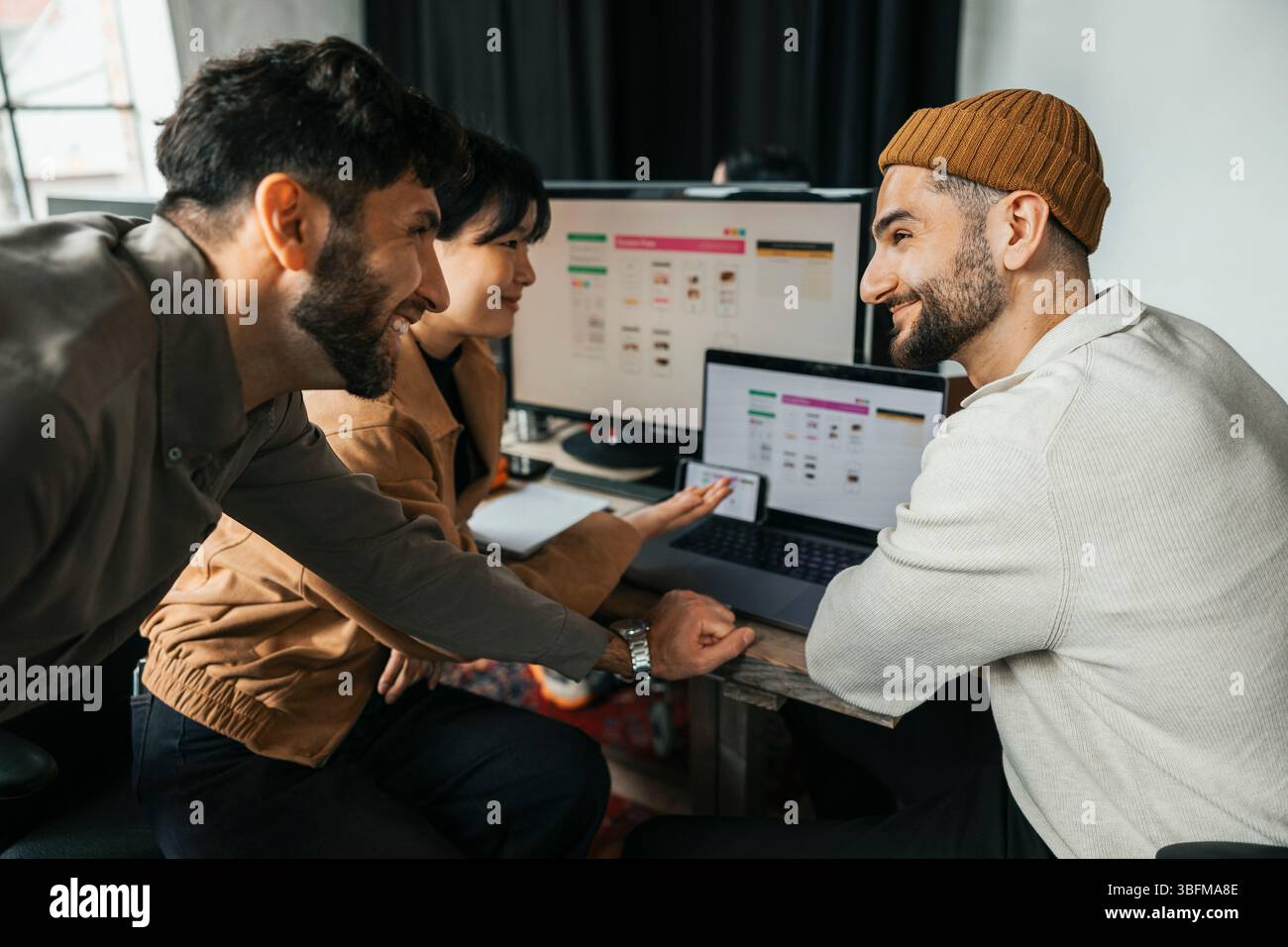 Happy male and female computer programmers smiling at each other Stock ...