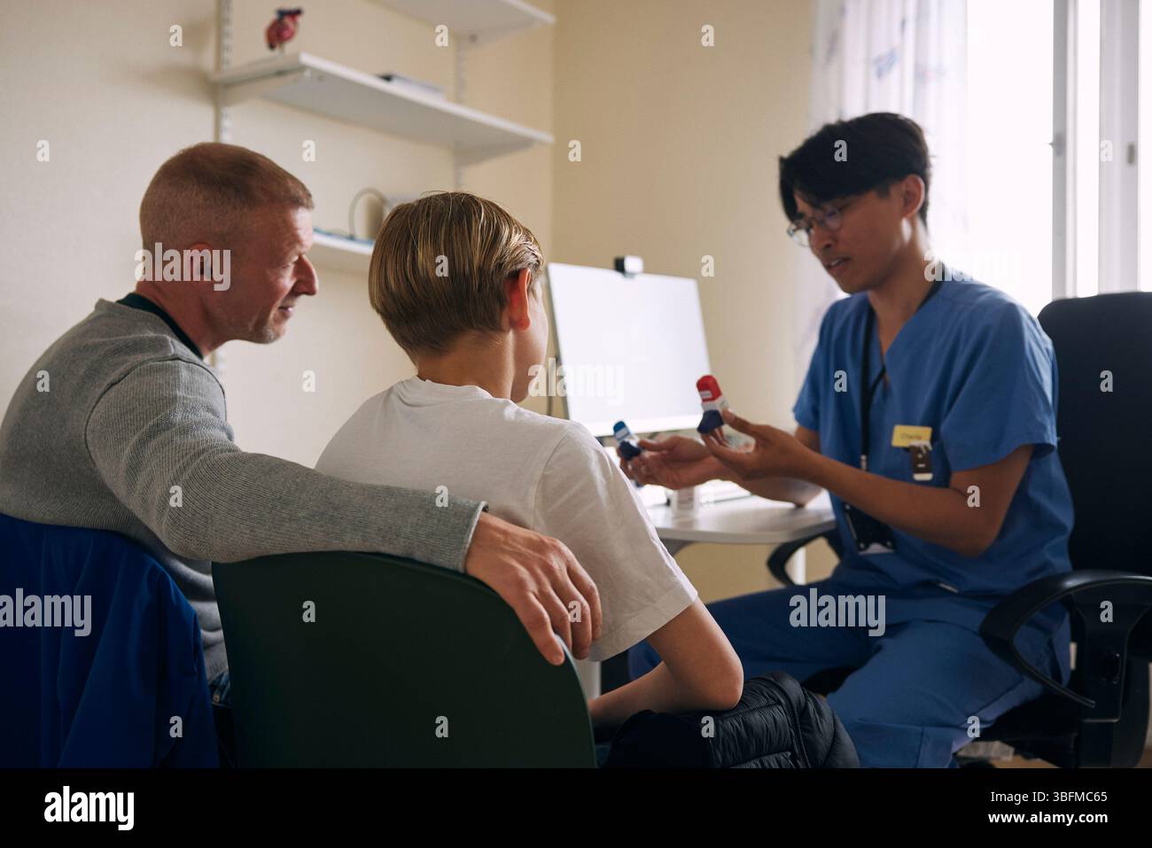 Doctor explaining types of asthma inhalers to patient during visit at ...