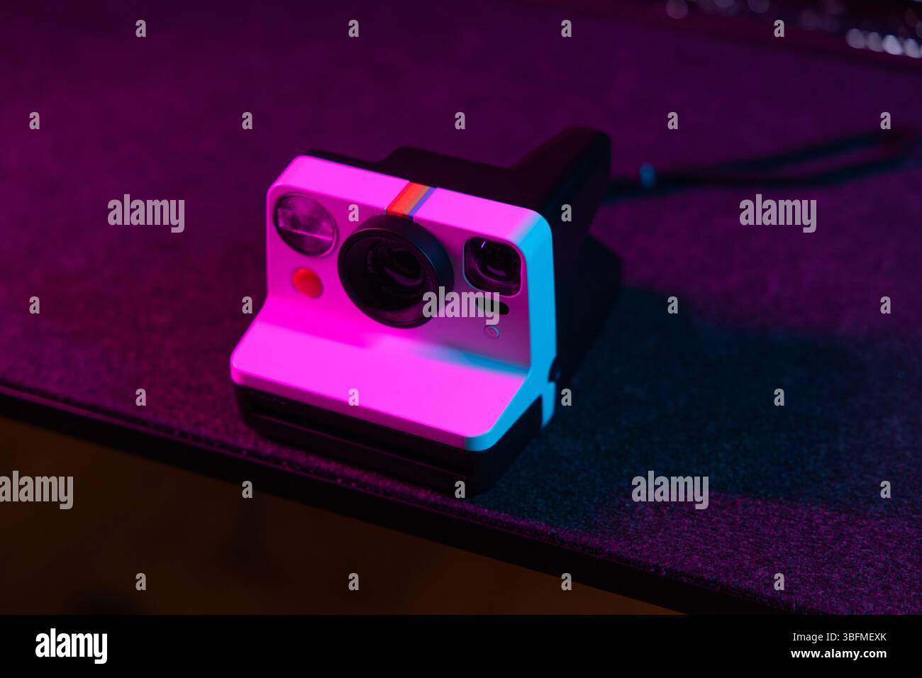 A modern instant camera with a retro design, featuring a rainbow stripe ...