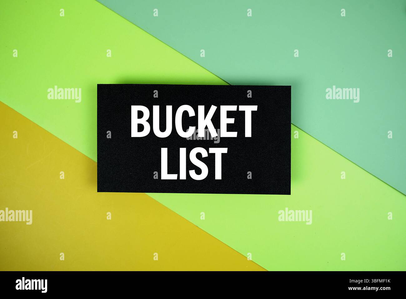 Bucket List text on paper card on green and yellow geometric background ...
