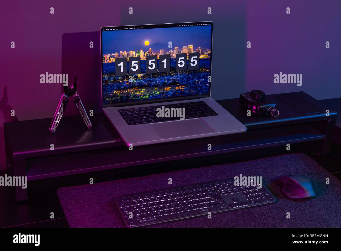 A personalized tech workspace at night, featuring a laptop with a city ...