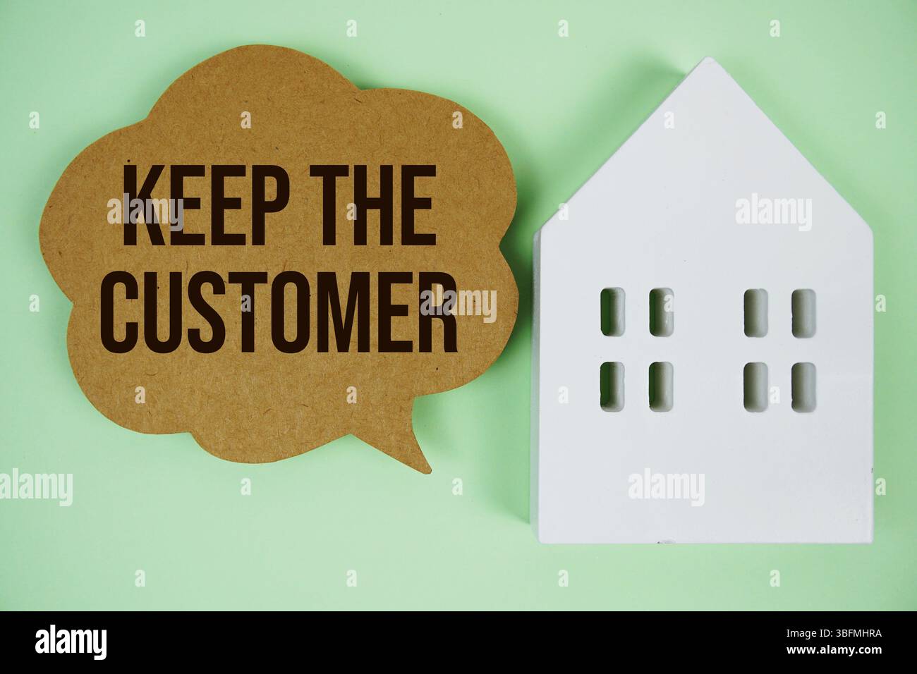 Keep The Customer text with house model on green background Stock Photo ...