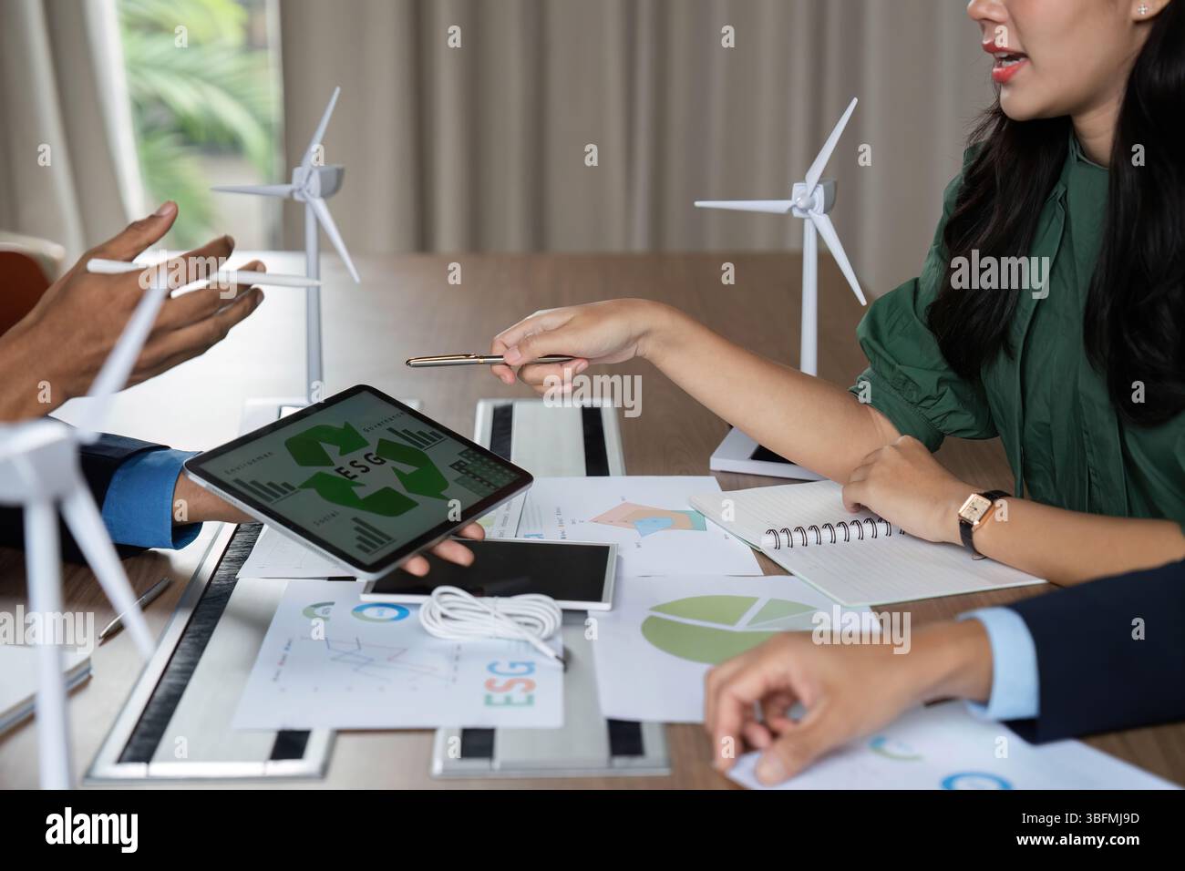 ESG Discussion with Digital Tools. Team analyzing sustainability data ...